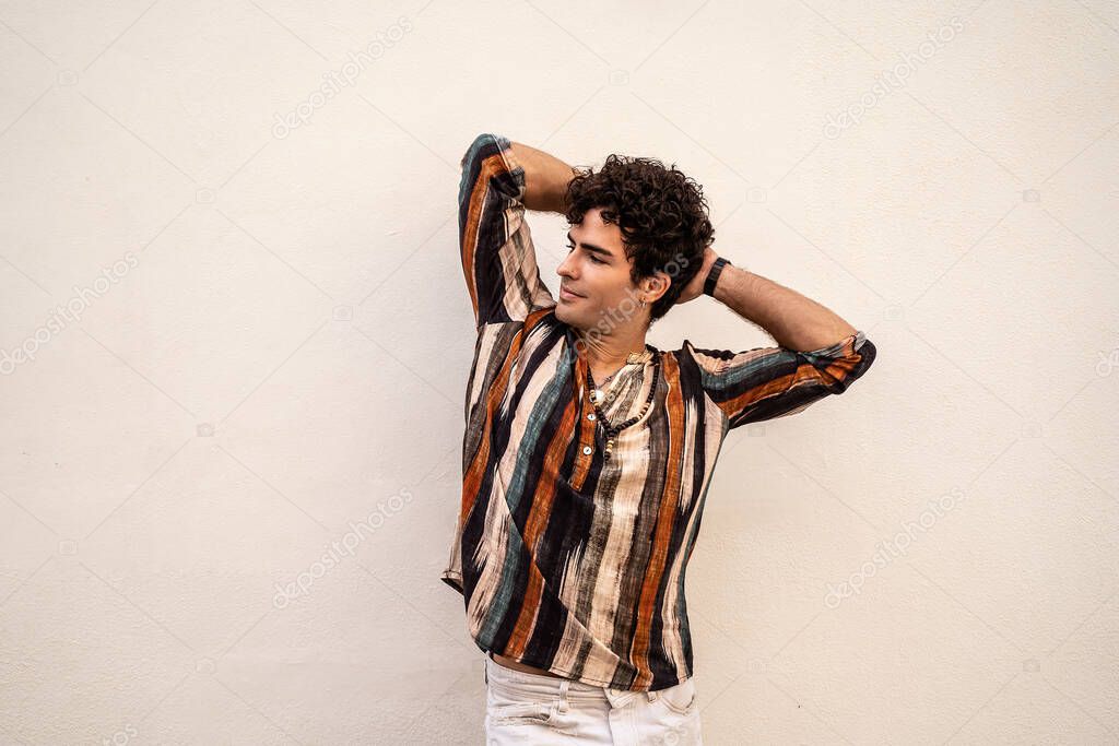 Un español guapo posando sobre la pared. Un hipster de moda. Relájate ...