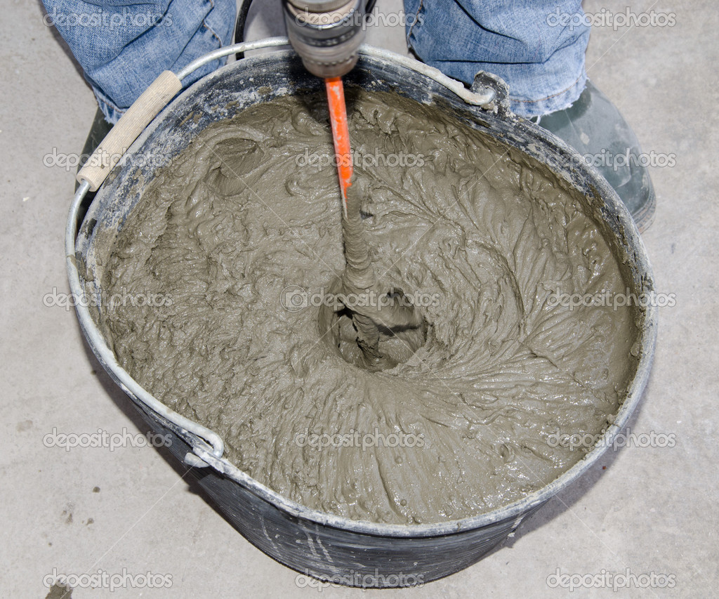 Tiler mixing tile adhesive with power drill in a bucket Stock Photo by ...