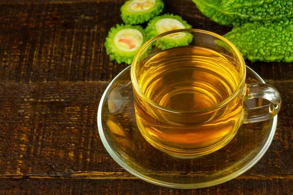 Bitter gourd or bitter melon tea in transparent cup and fresh bitter ...