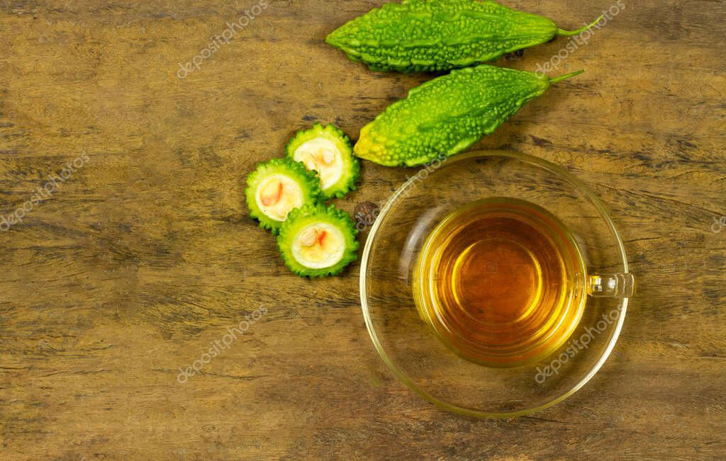 Bitter gourd or bitter melon tea in transparent cup and fresh bitter ...