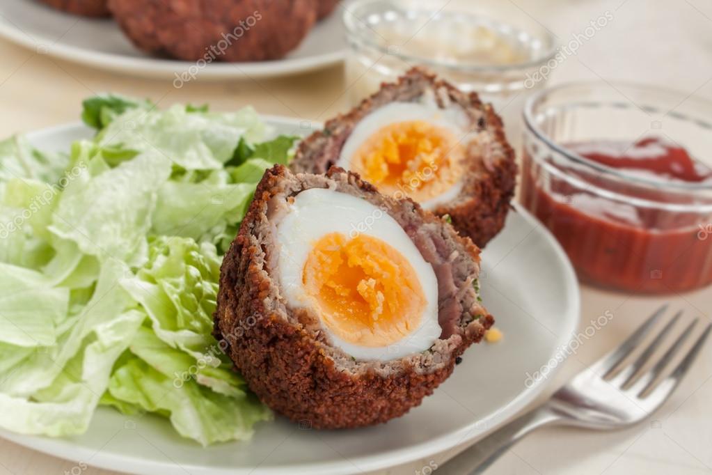 Scotch eggs cut in halves on a plate — Stock Photo © Nalga #42004303