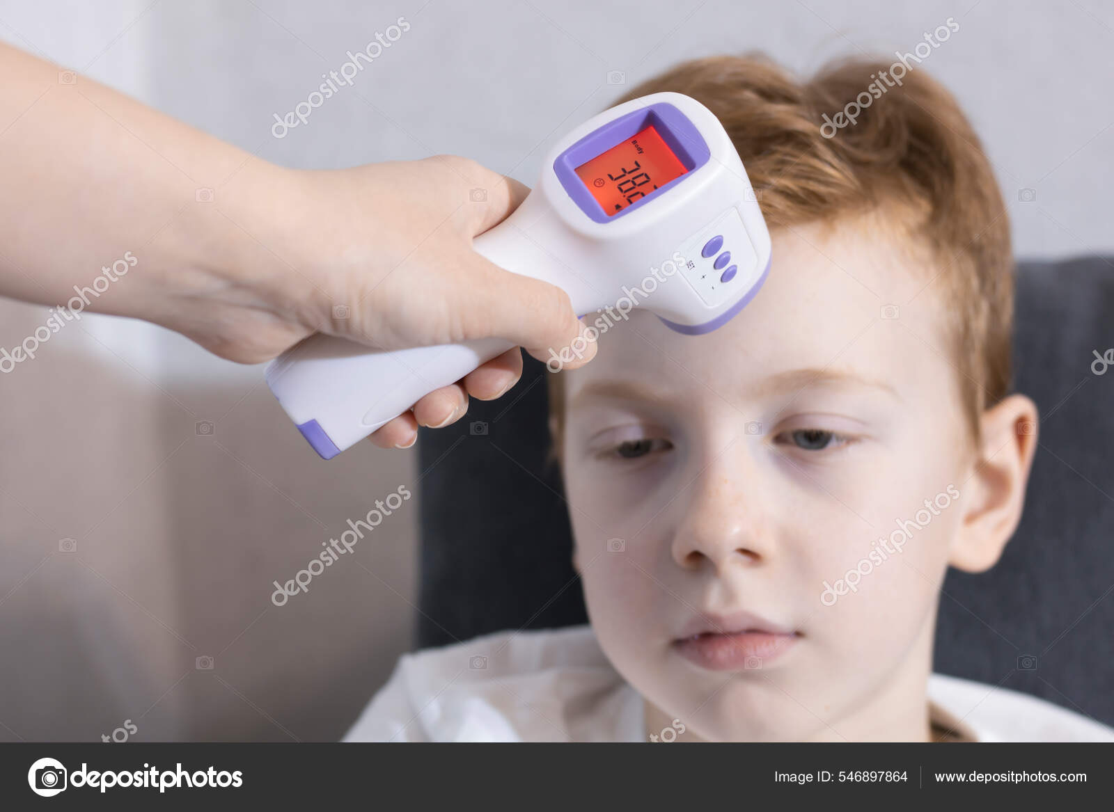 The hand uses a modern electronic infrared thermometer, the boys body ...