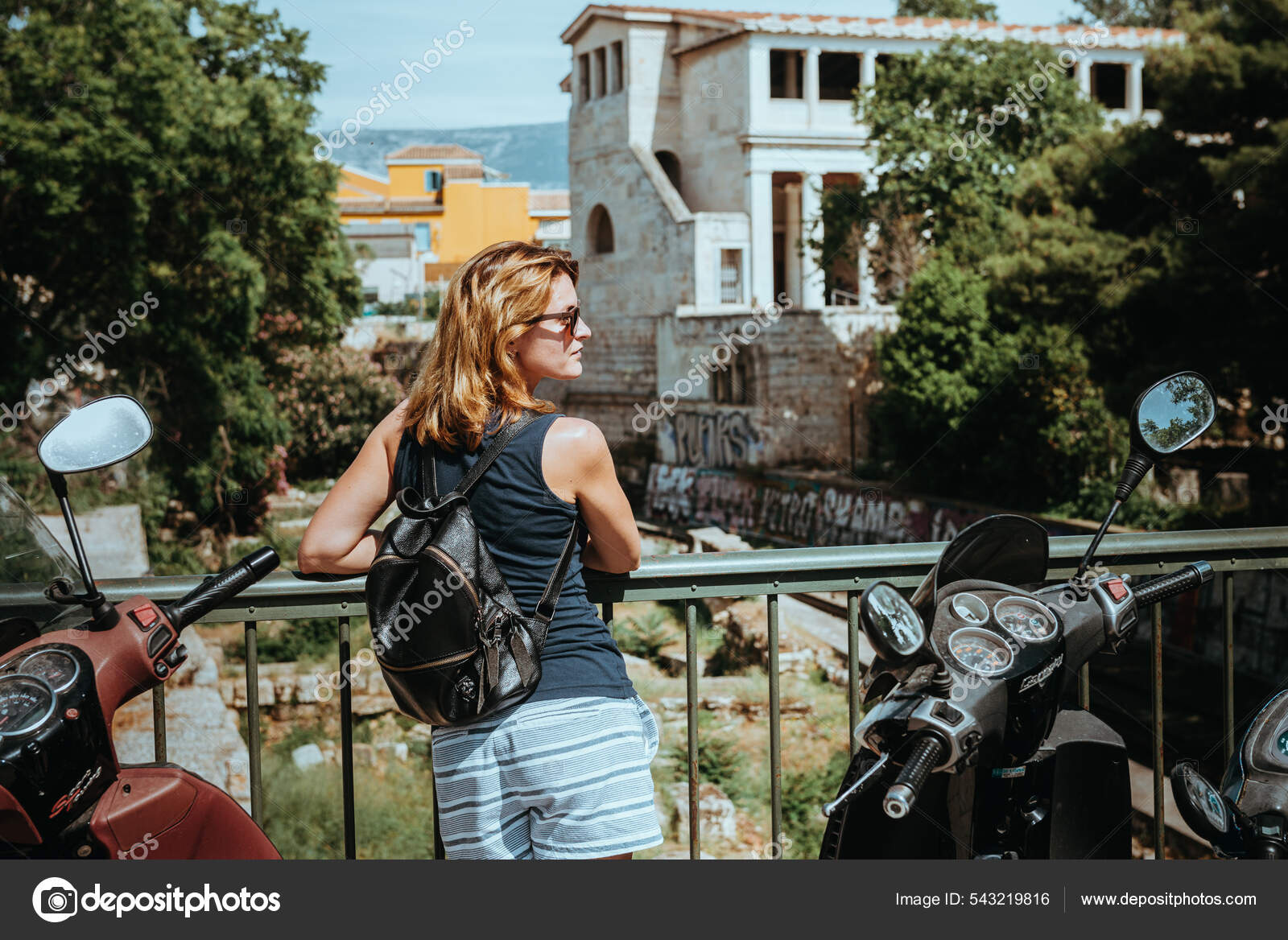 Beautiful girl walking along the street of an old European town ...