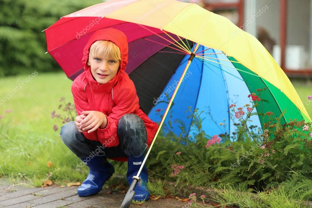 Boy hiding from rain sitting under umbrella Stock Photo by ©CroMary ...