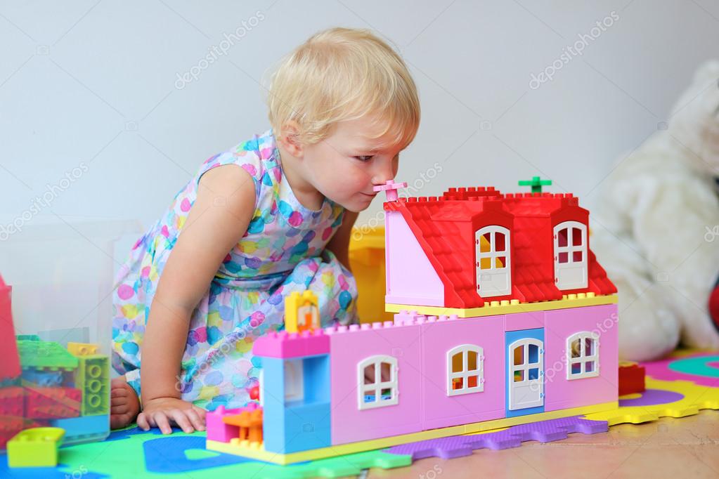 Happy little girl building house from colorful plastic blocks Stock ...