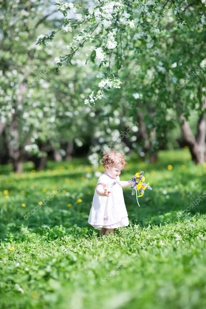 Beautiful little girl playing with flowers — Stock Photo © FamVeldman ...