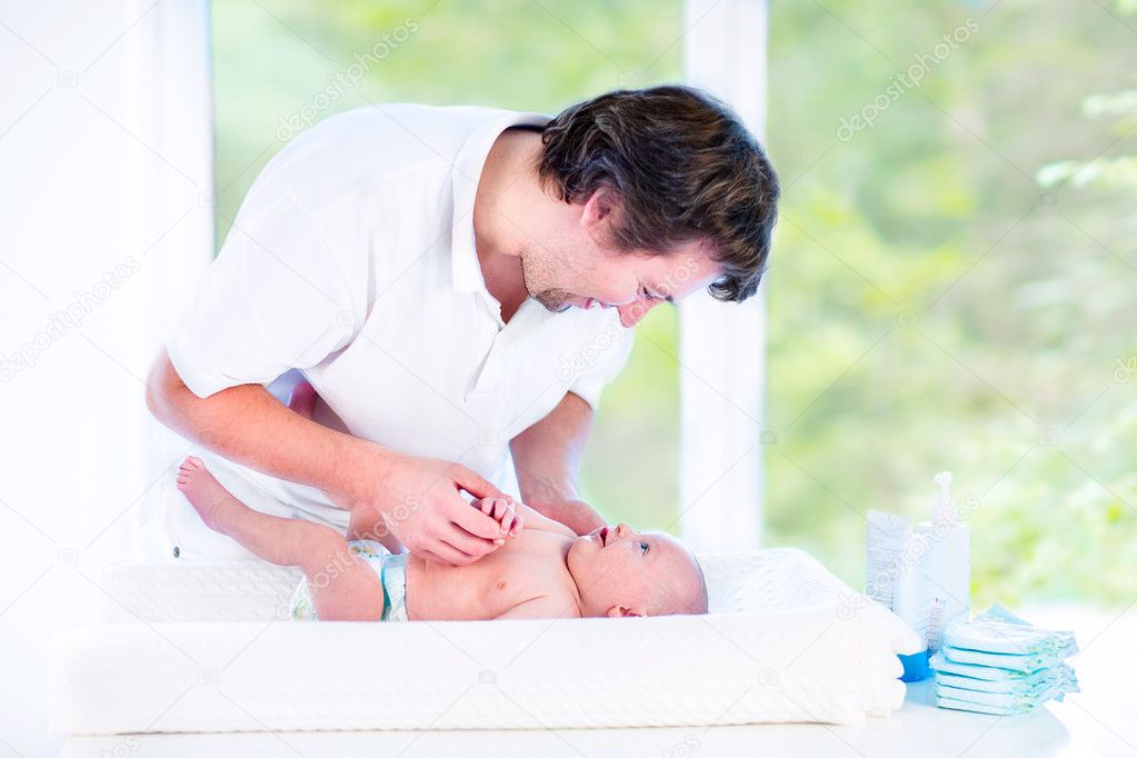 Young loving father changing diaper of his newborn baby son Stock Photo ...