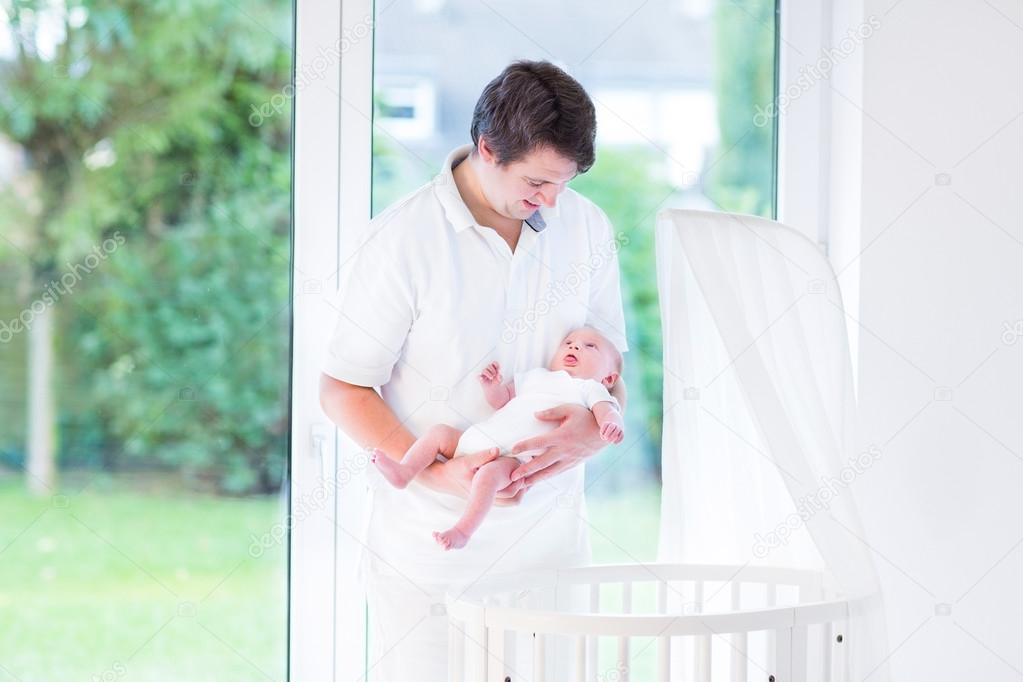 Young smiling father putting his newborn baby Stock Photo by ...