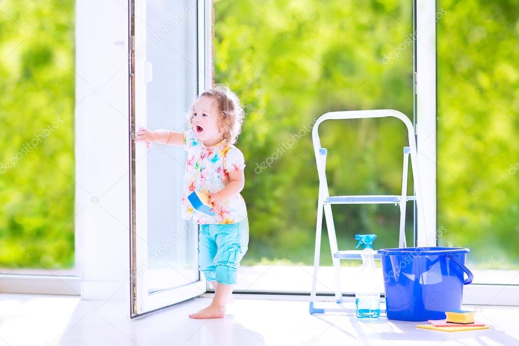Little girl washing a window — Stock Photo © FamVeldman #46990773