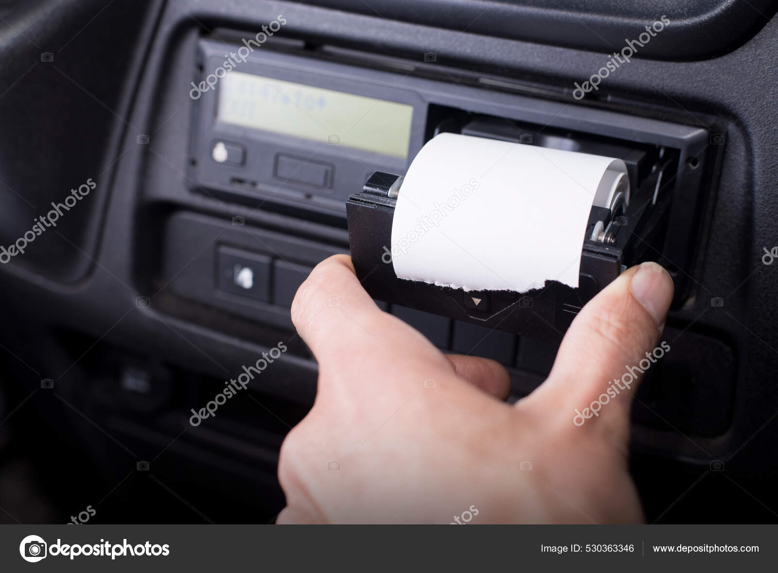 Digital tachograph with an open printer and visible roll of paper ...