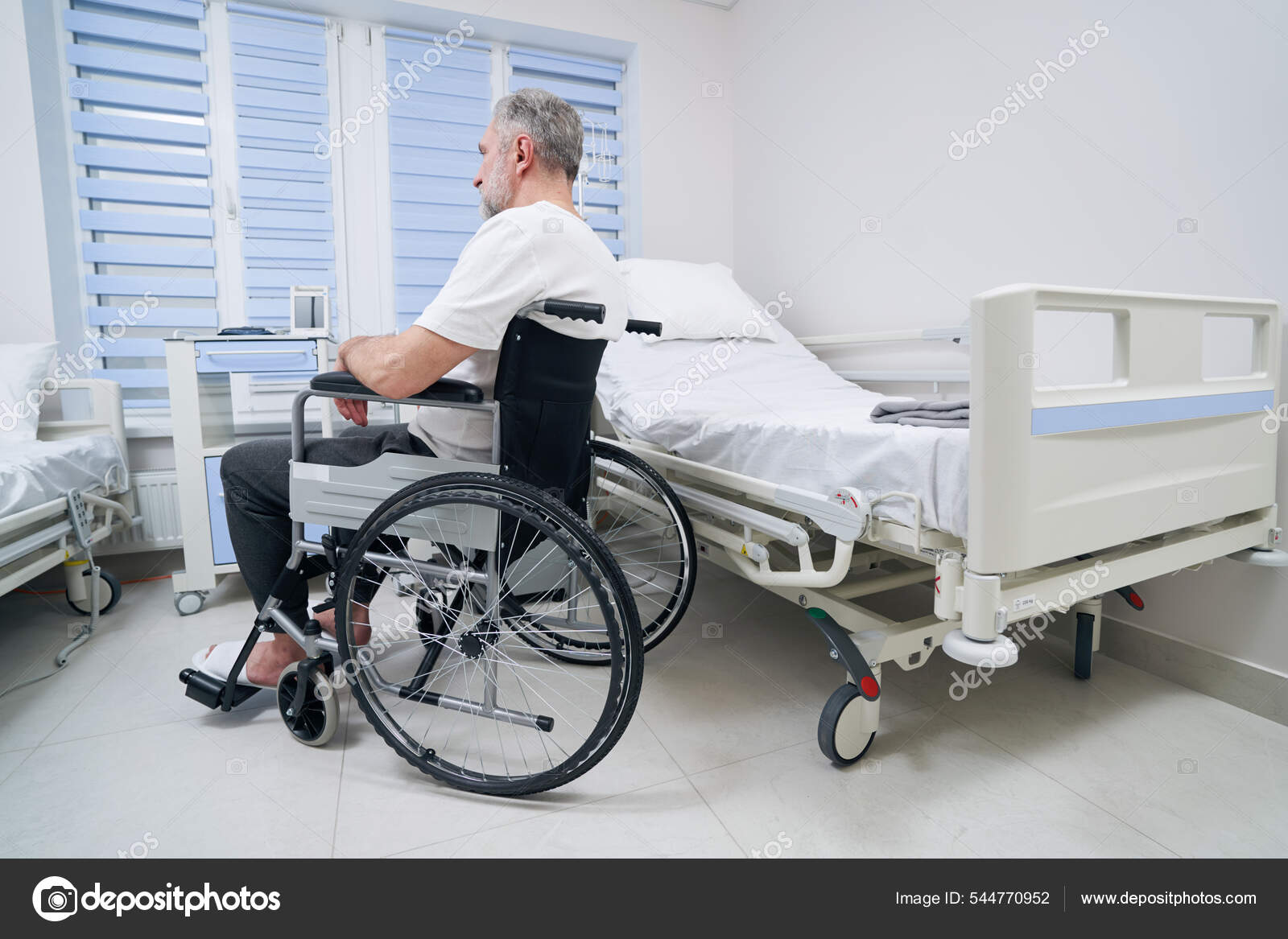Disabled person seated in wheeled chair in rehabilitation facility ...