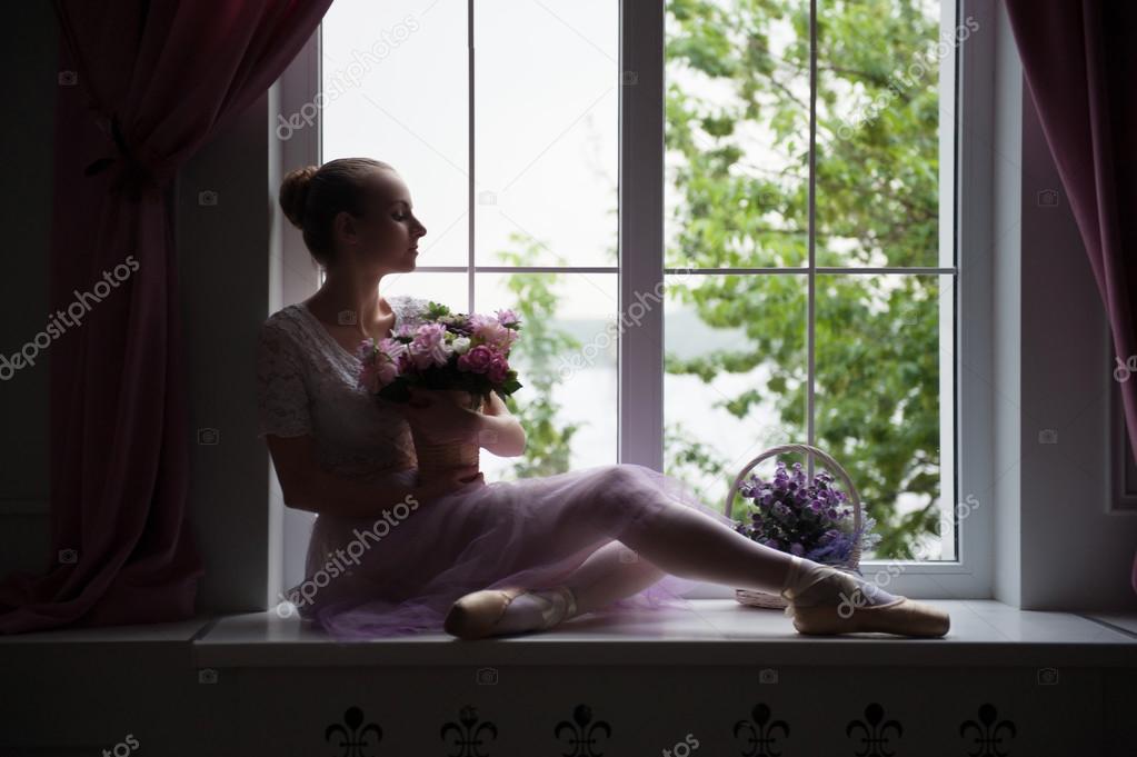 Ballet dancer sitting on windowsill holding flowers Stock Photo by ©Dmyrto_Z 50555741