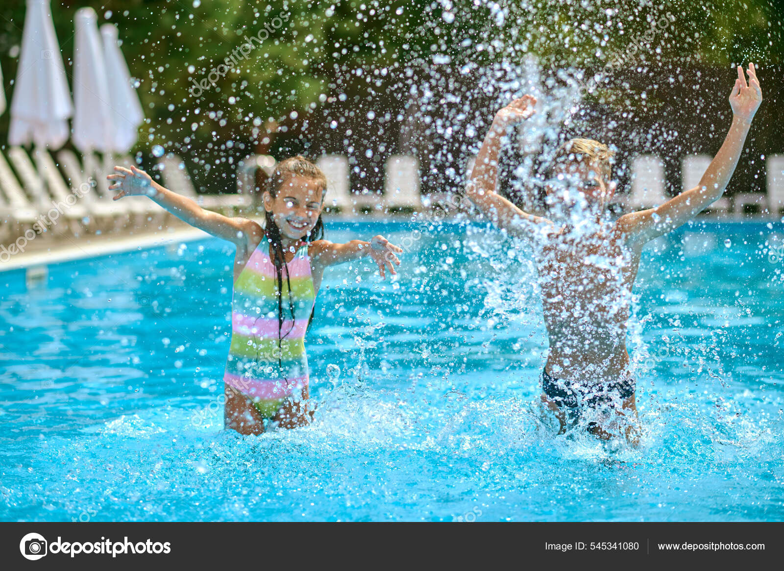 Children splashing water on camera while standing in pool — Stock Photo ...