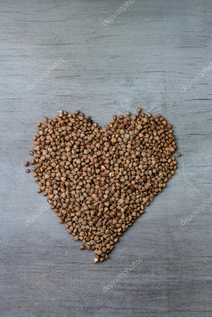 Buckwheats grains formed in heart shape on wooden background Stock ...