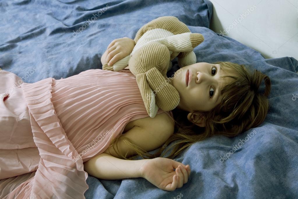 Desperate little girl lying on the bed — Stock Photo © elenarostunova ...