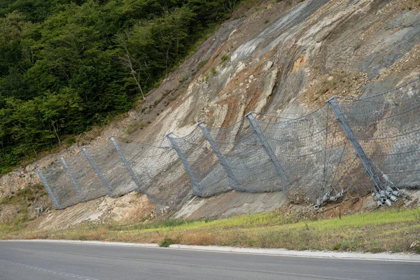 Active robust rockfall barrier system with wire mesh along the road ...