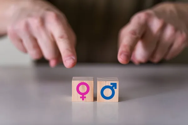 A choice between a man and a woman. the hands point to two wooden cubes ...