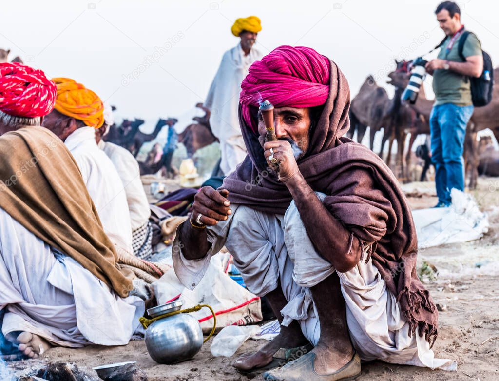 Pushkar, Rajastán, India - Oct 2017: Hombre indio de Rajastán fumando en el recinto ferial ...