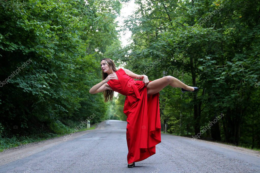 Fantasía Hermosa bailarina chica bailando en la carretera. Árboles de fondo de naturaleza otoñal ...
