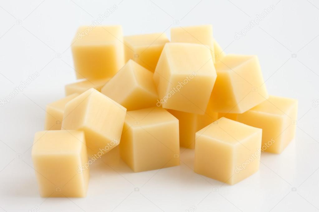 Cubes of yellow cheese stacked randomly on white. Stock Photo by ...