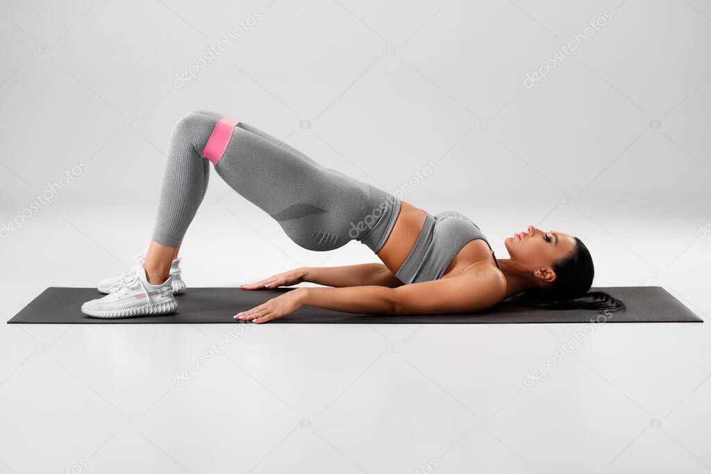 Chica atlética haciendo ejercicio puente de glute con banda de ...