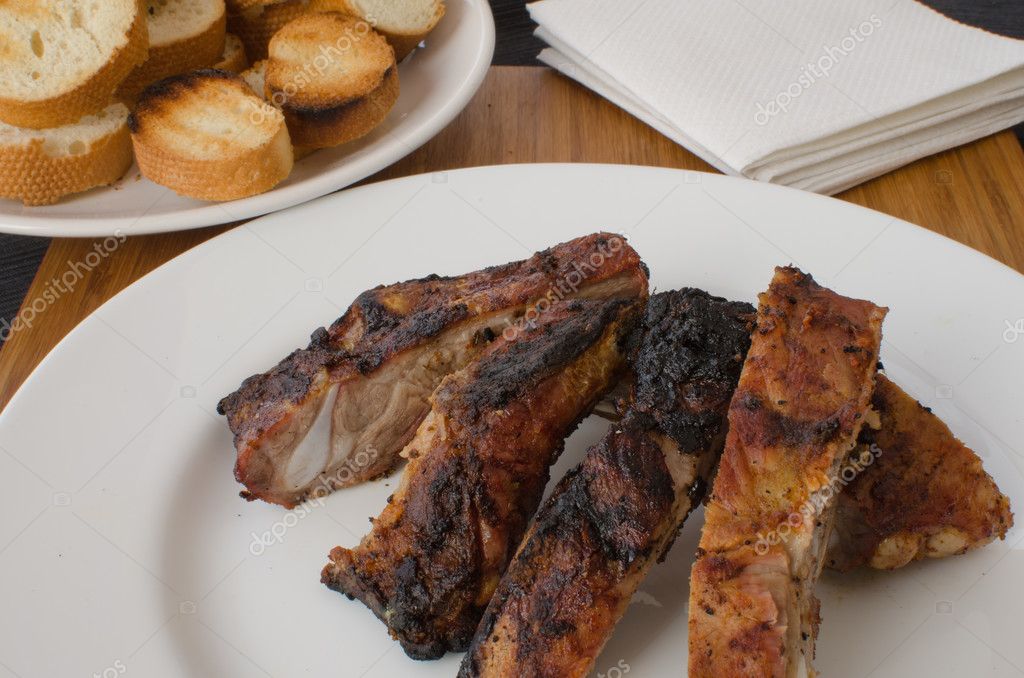 Spareribs on grill with dip and toasted baguette — Stock Photo © Peteer ...