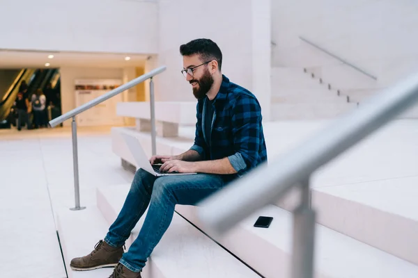 Caucasian male programmer working remotely with software update on laptop computer using 4g ...