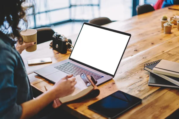 Female student with takeaway coffee e learning on laptop computer with ...