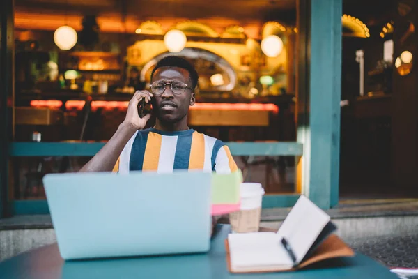 Portrait of serious male programmer in optical glasses looking at ...