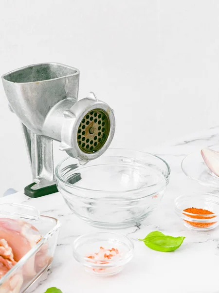 Hand retro chopper with empty glass dish, boneless chicken thighs, pink ...