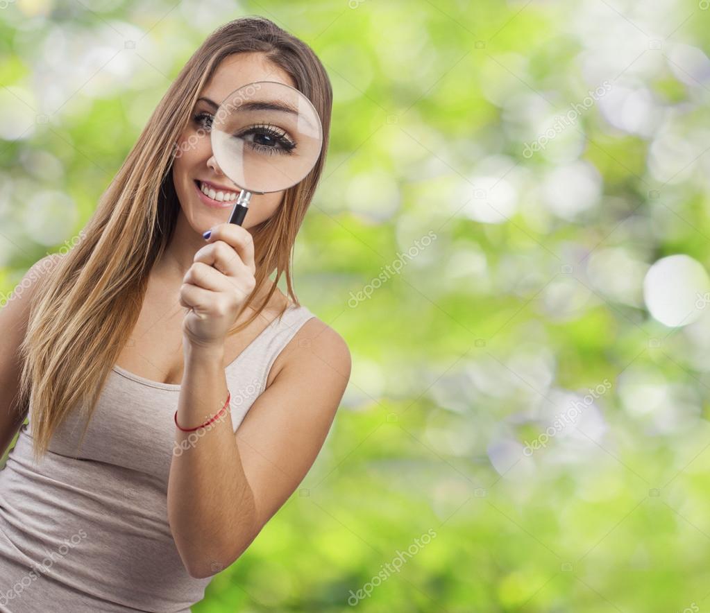 Woman looking through magnifying glass Stock Photo by ...