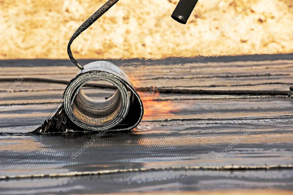 El proceso de instalación de material para techos utilizando un soplete ...