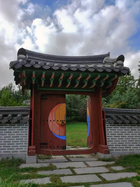 The open gate is decorated with the decor of a Korean religious temple ...