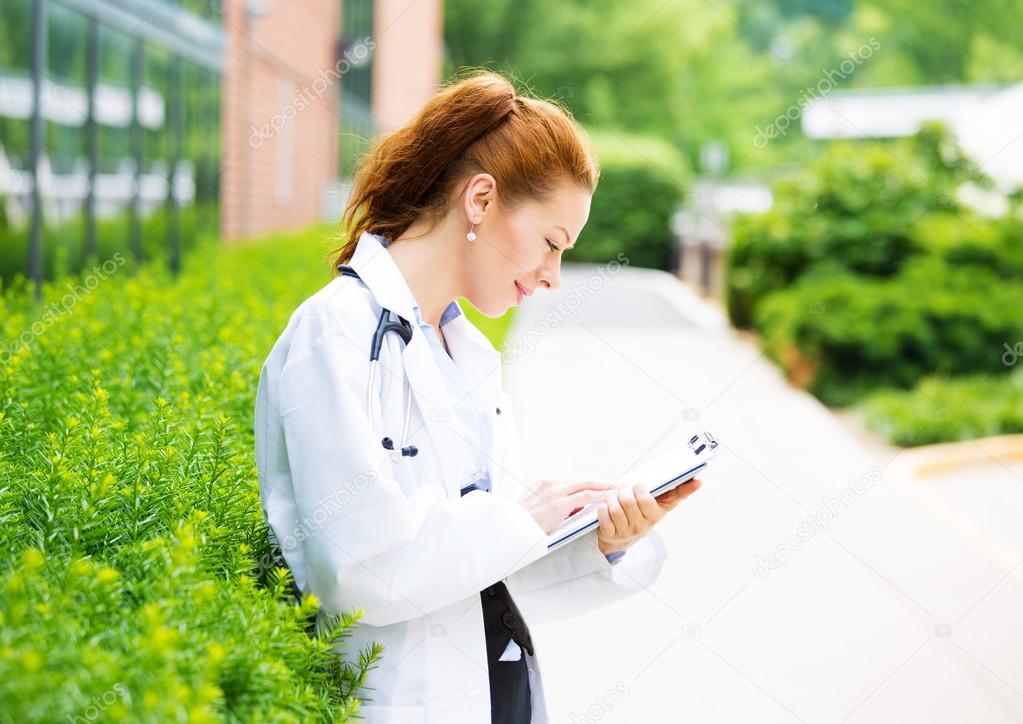 Doctor reading chart outside hospital — Stock Photo © SIphotography ...