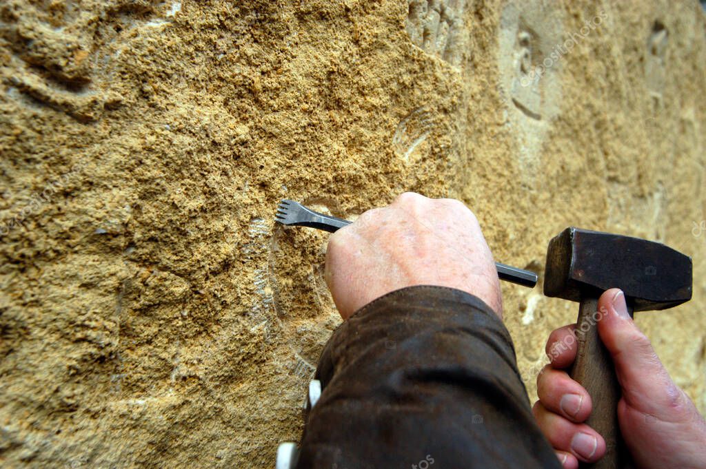 a stonemason working with stone, craft for construction and sculpturing ...