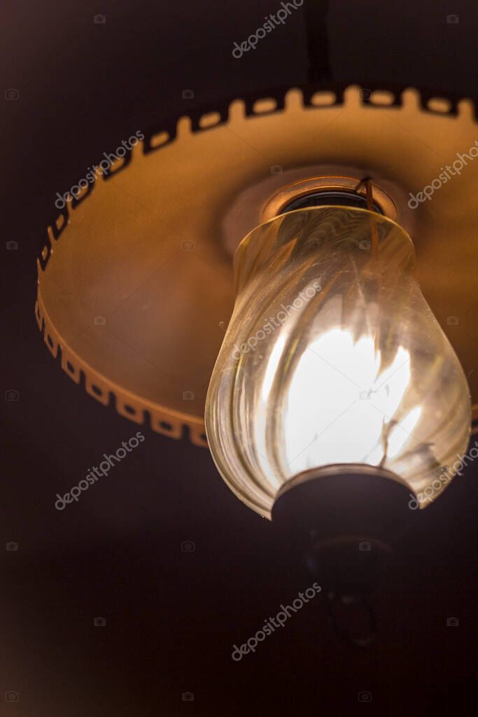 Luz de una lámpara colgada en el techo en una habitación oscura 2024