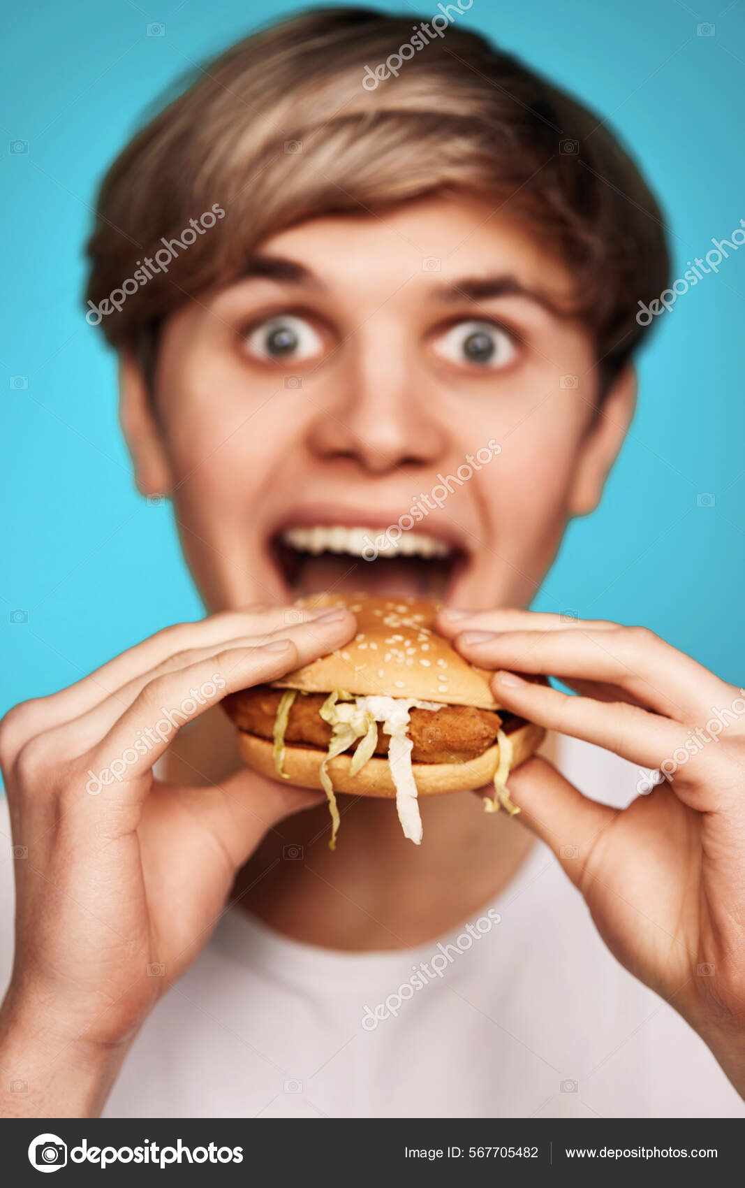 Very hungry young man holding tasty hamburger Stock Photo by ©erstudio ...