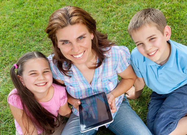Happy Family using laptop lying on grass - Stock Image - Everypixel