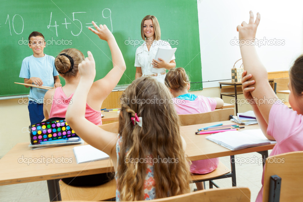 estudiantes de escuela primaria en el escritorio del salón de clases ...