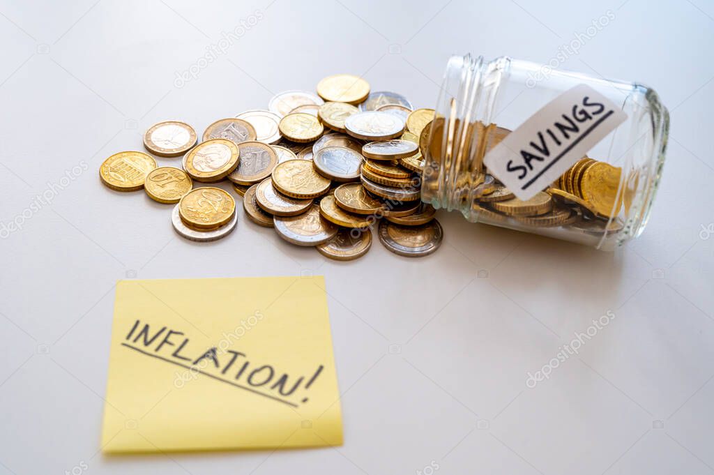 Hucha, etiquetada con la palabra "ahorro", con monedas y billete amarillo con texto "inflacci n ...