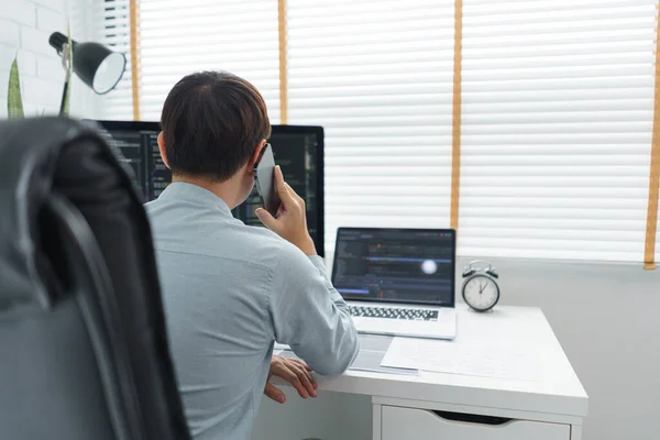 Software development concept, Male programmer talking on smartphone and ...