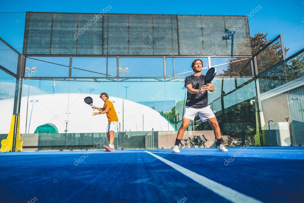 Partido de padel mixto en una cancha de padel de hierba azul - 2022