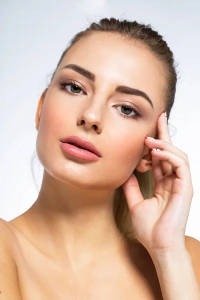Closeup front portrait of a young woman with natural makeup, looking at ...