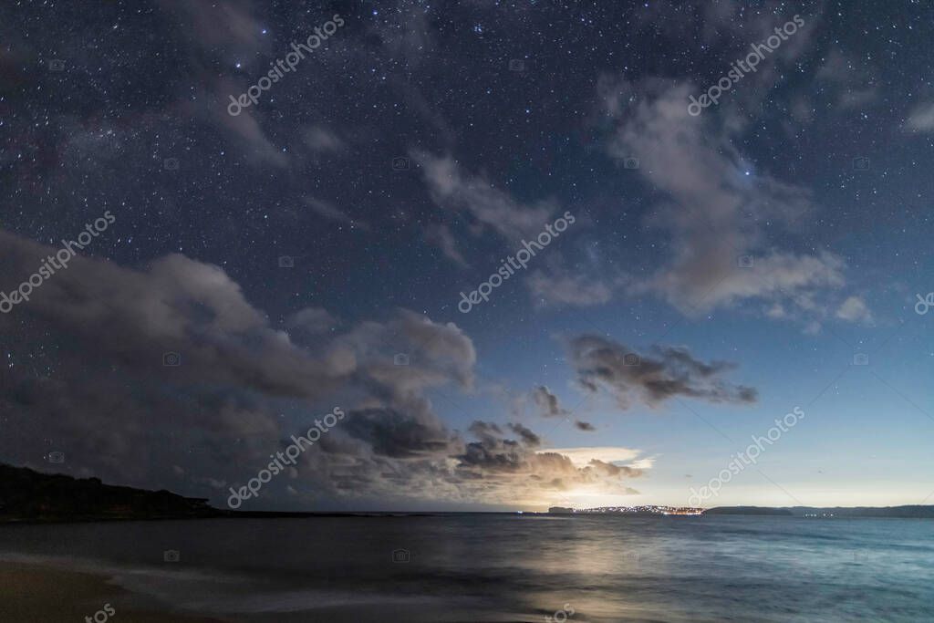 In the dark of the night at the beach under the Milky Way sky and stars ...