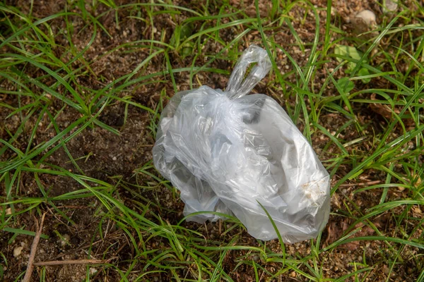 Plastic bags waste on the grass. Garbage dumped on the grass ...