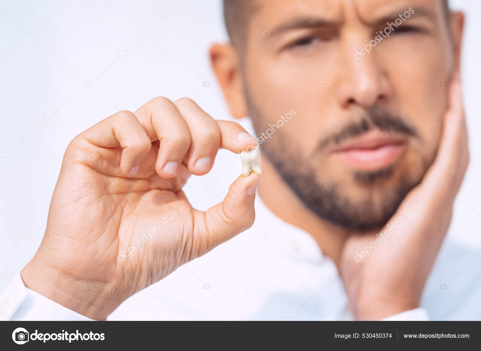 Man with extracted tooth after tooth removal surgery. Pain after tooth ...