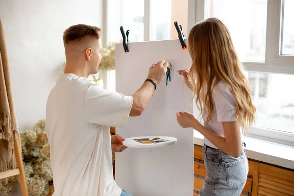 Young couple drawing together. Girlfriend and boyfriend spending time ...