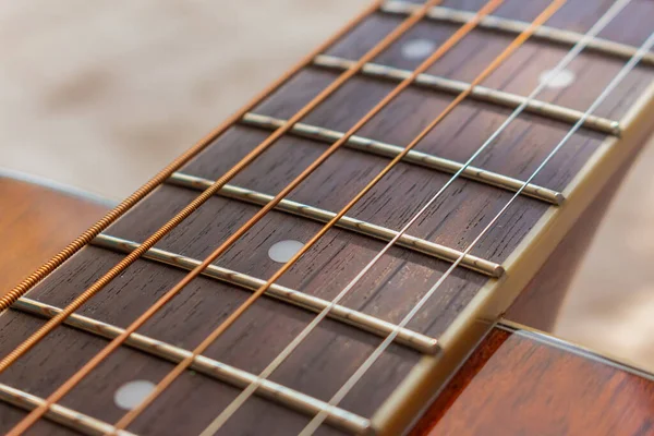 Guitar neck, stretched strings, frets and texture of natural material ...