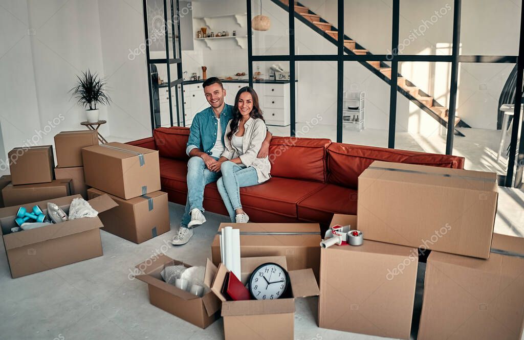 Pareja casada joven sentada en el sofá en la sala de estar en casa ...