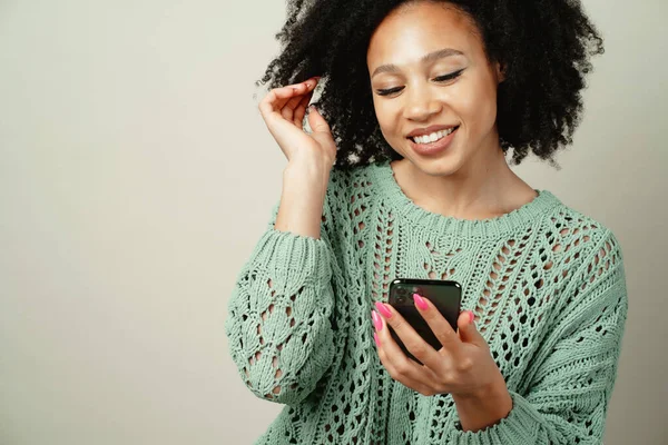 prints a text message on the phone to a friend and smiles lookin ...